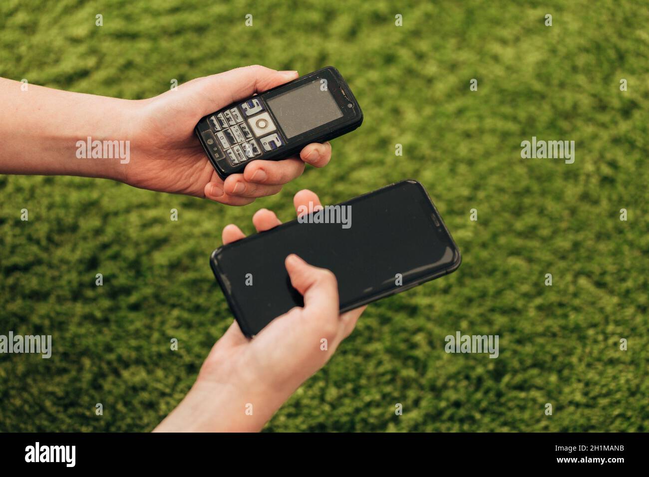 The Human Hand Picks an Old Phone That Lies Near New Smartphones Stock ...
