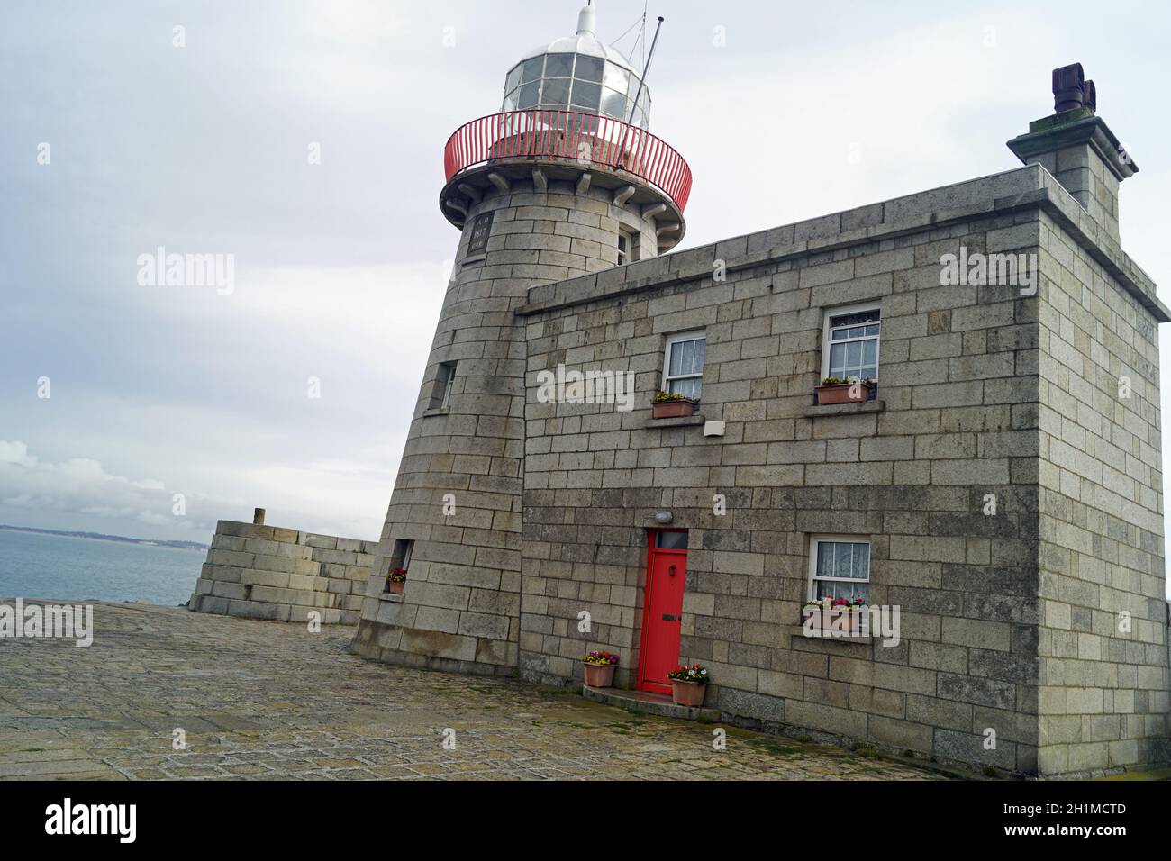 The lighthouse guards the entrance to the port of Howth Stock Photo - Alamy