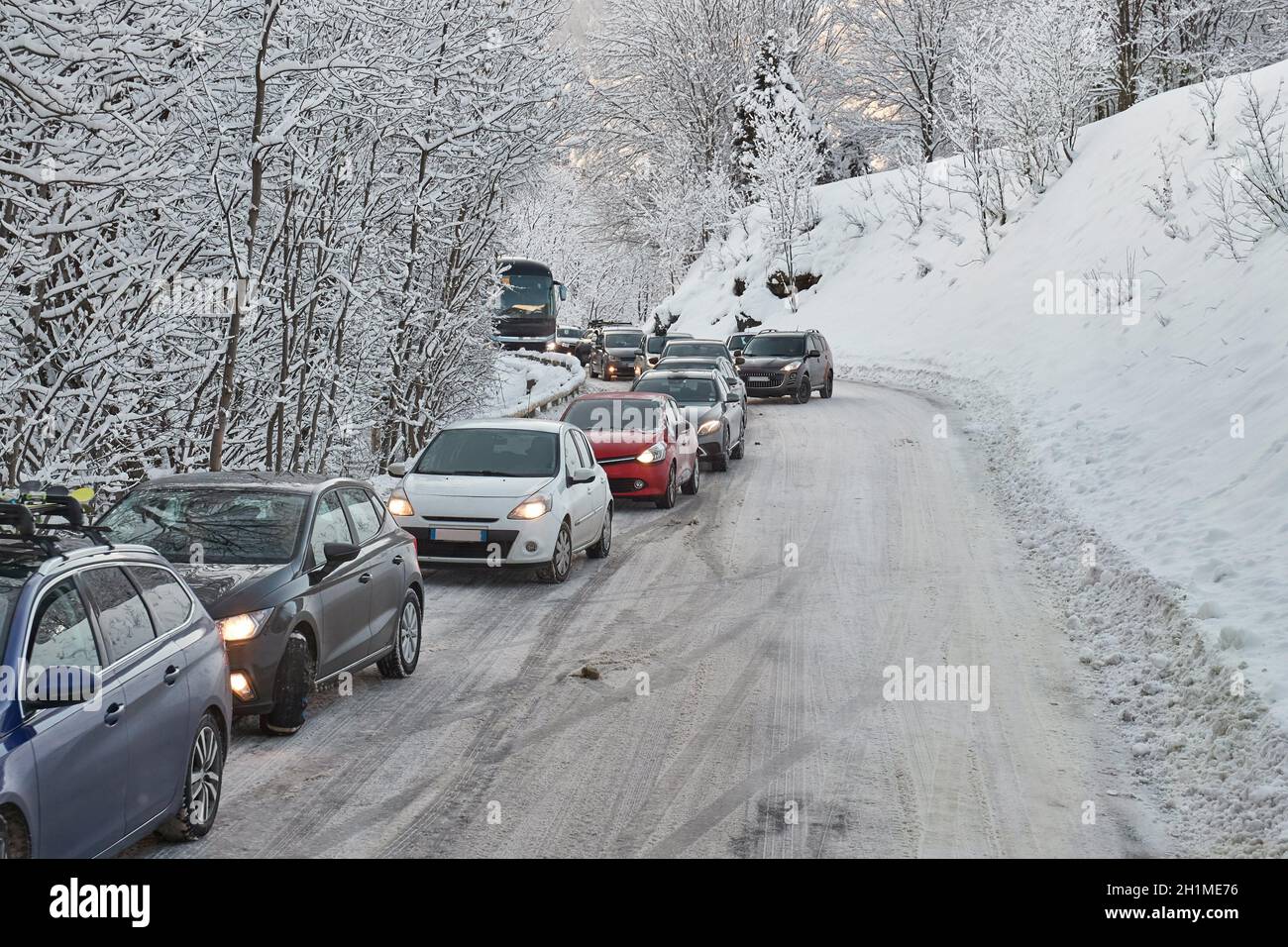 Cars after a blizzard on an alpine road, congestion with line of ...