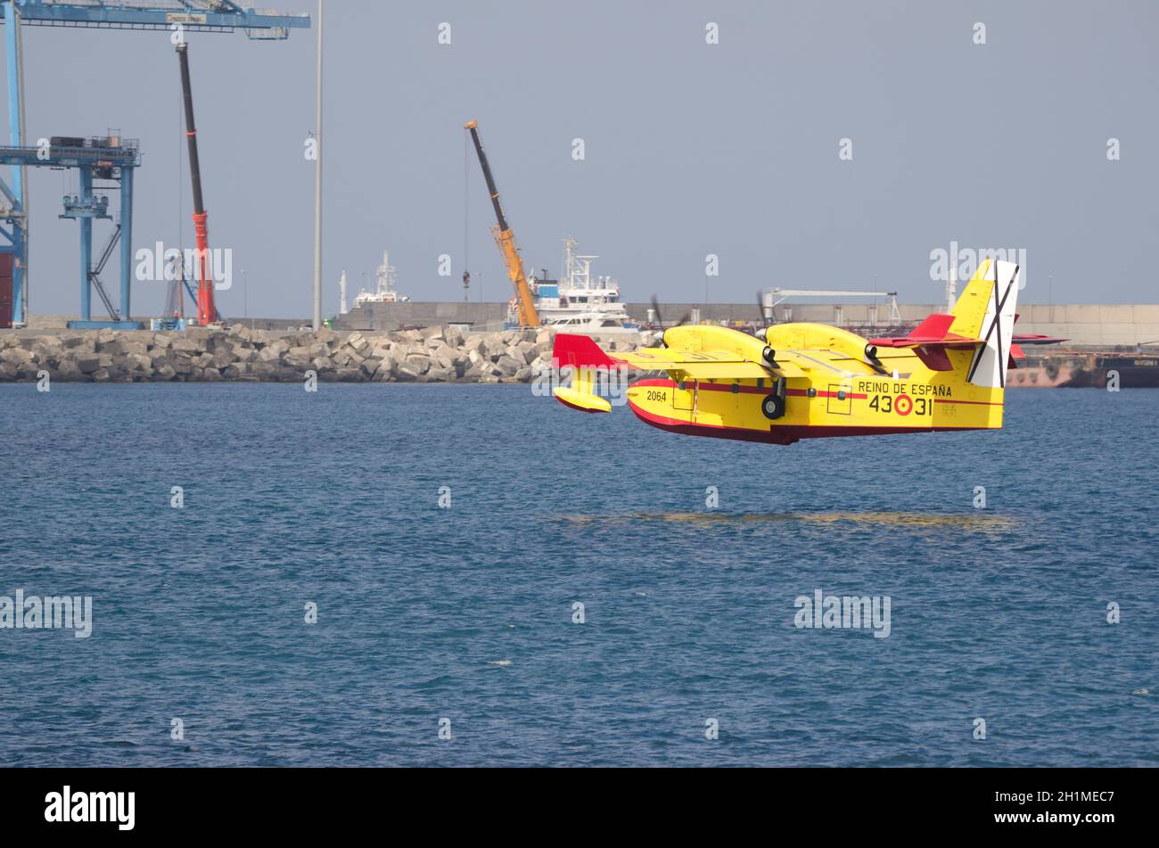 Fire-fighting plane collecting sea water to extinguish a forest fire ...