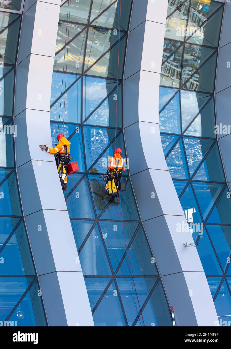 The window cleaner working on a glass facade modern skyscraper Stock ...