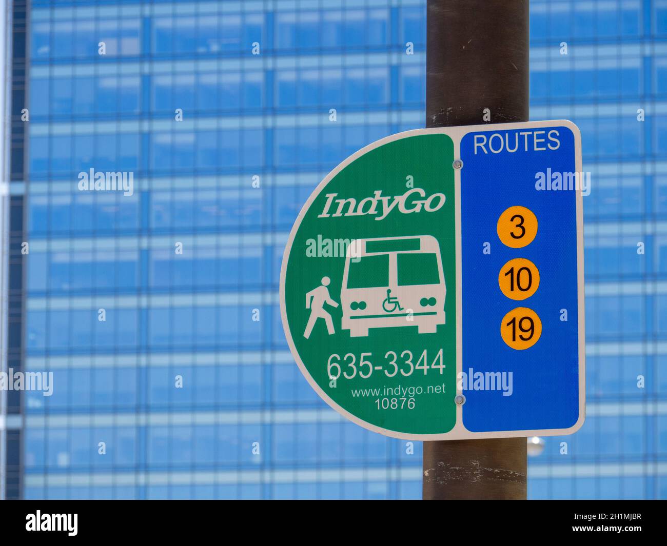 IndyGo Bus Stop Sign Routes 3 10 19 in front of a Blue Office Building ...