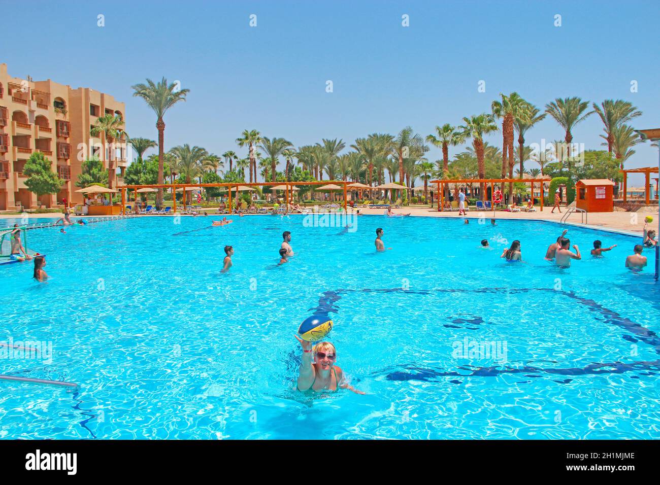 People enjoy relaxing at tropical resort in pool in Egypt. Swimming ...