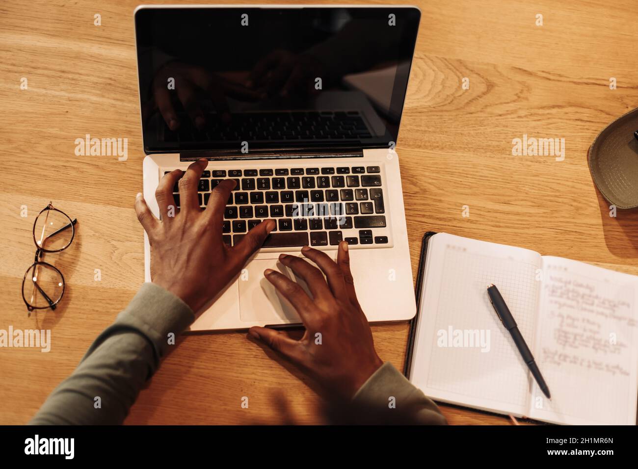 close-up of hands are typing on a laptop. laptop with notepad and pen ...