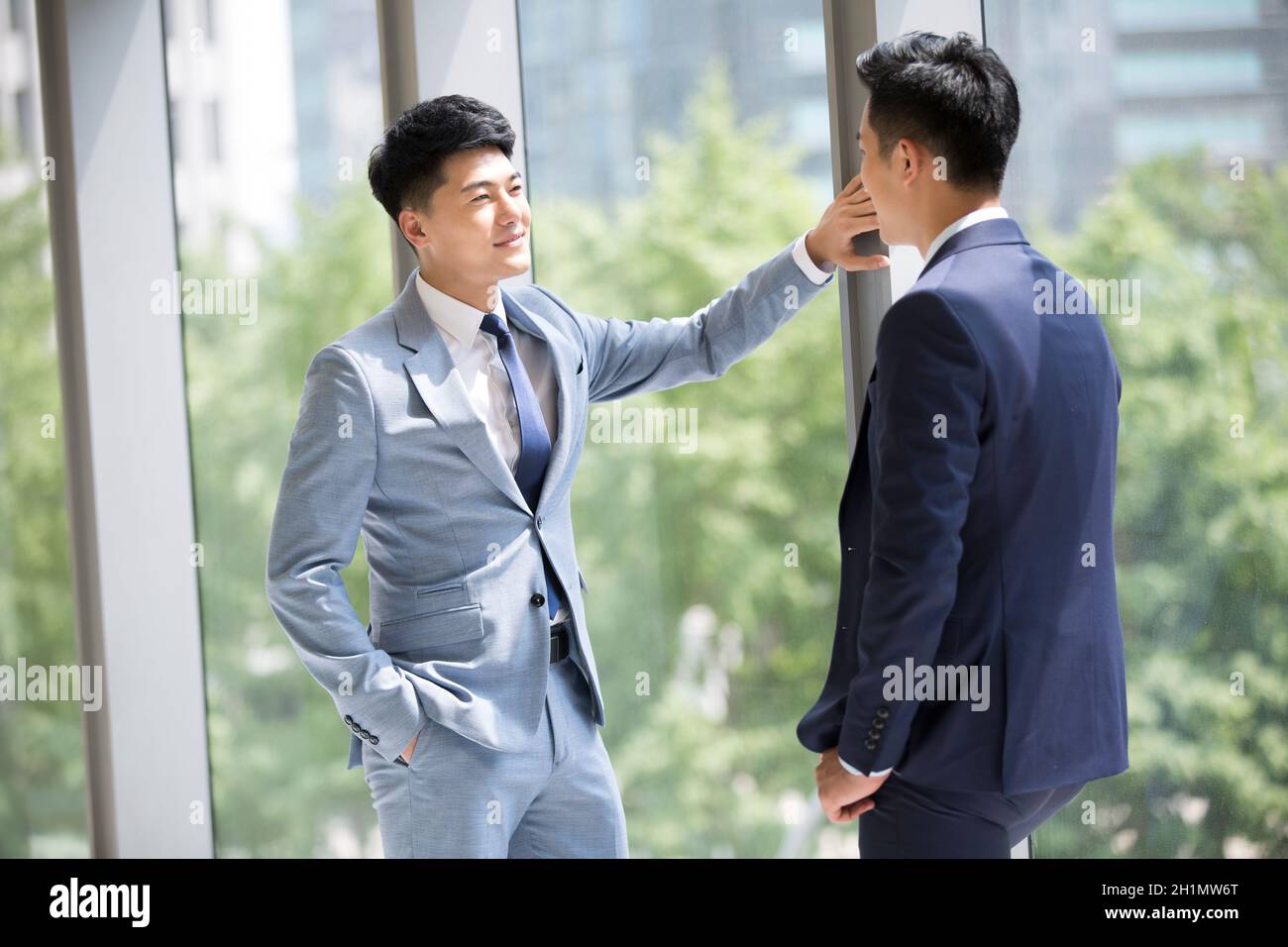 Businessmen talking by the window Stock Photo - Alamy