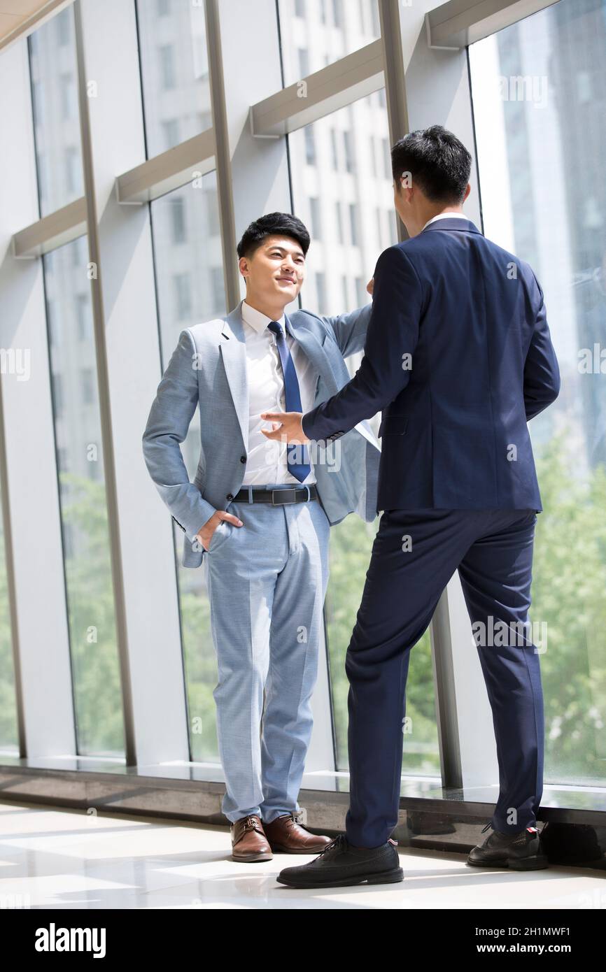 Businessmen talking by the window Stock Photo - Alamy