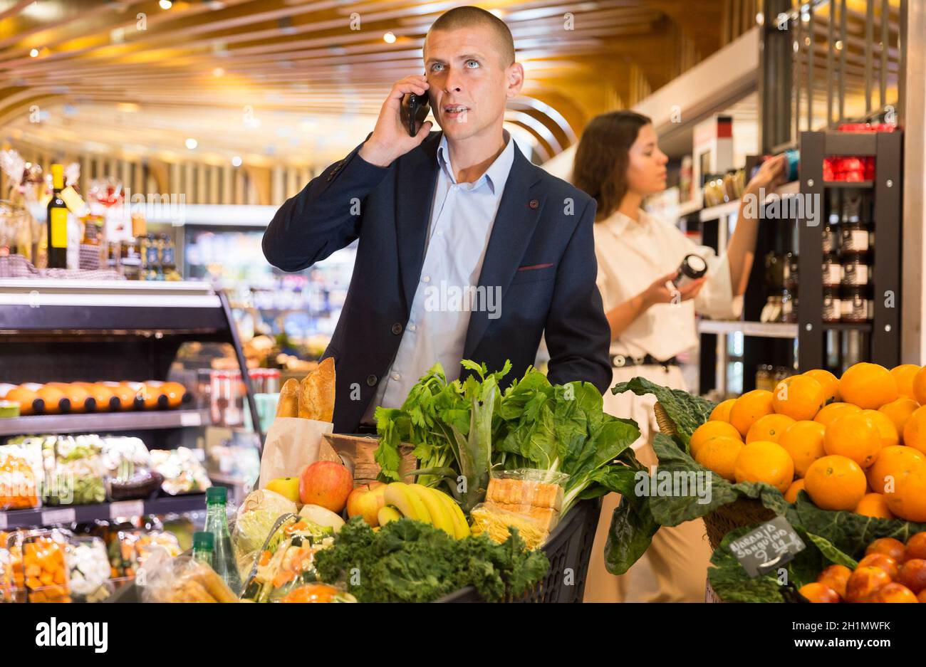 Man in supermarket on phone hi-res stock photography and images - Alamy