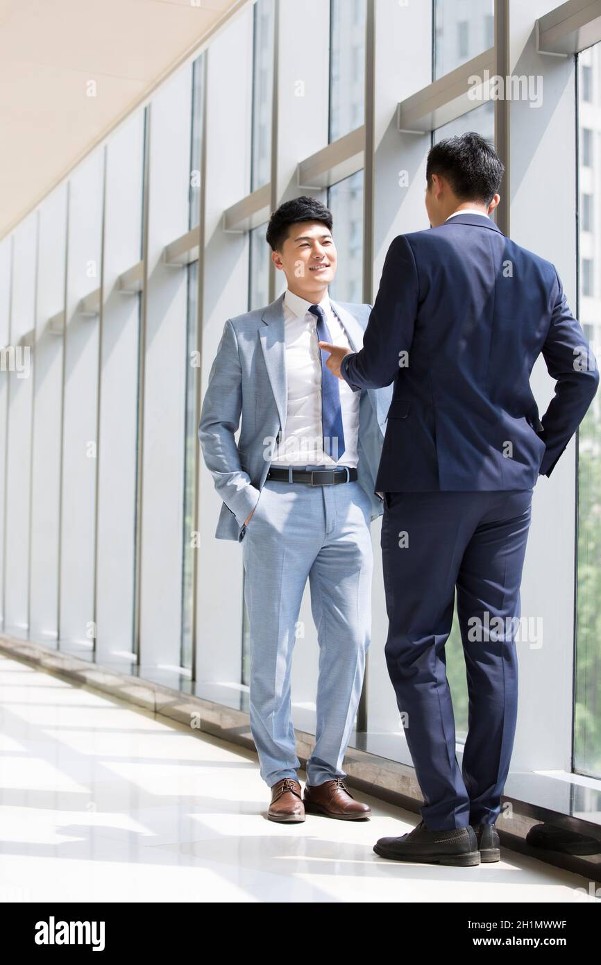 Businessmen talking by the window Stock Photo - Alamy