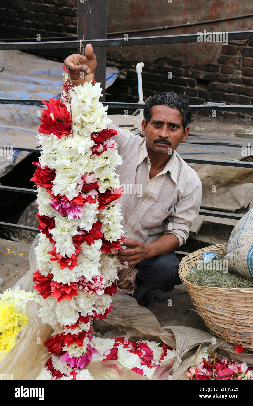 People buying and selling flowers and garlands at the flower market in ...