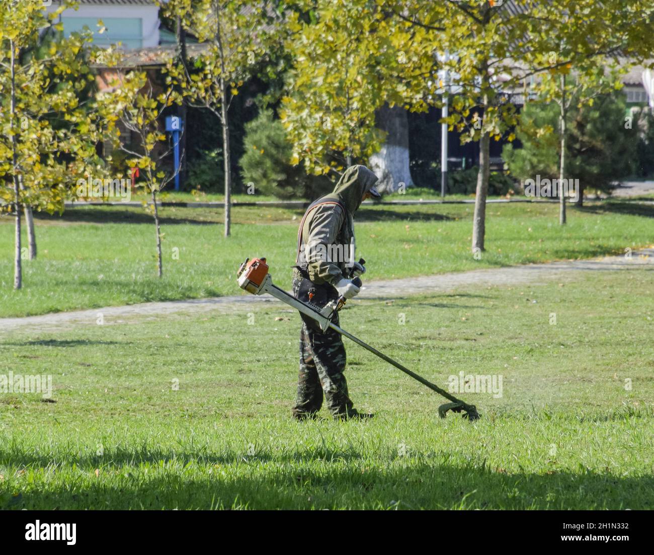 Worker mowing the lawn. Mowing grass trimmer Stock Photo - Alamy