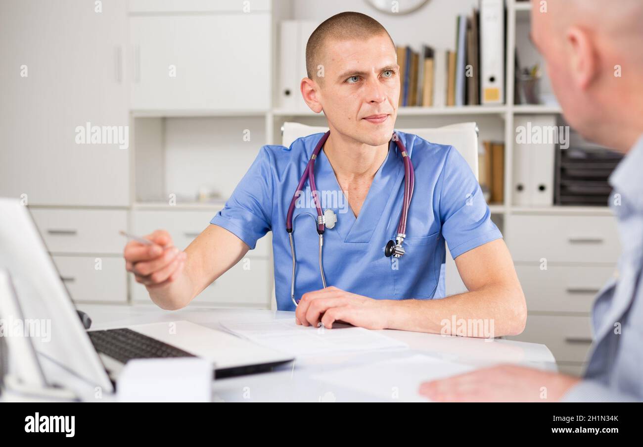 Male doctor in the clinic consults a patient in the office Stock Photo ...