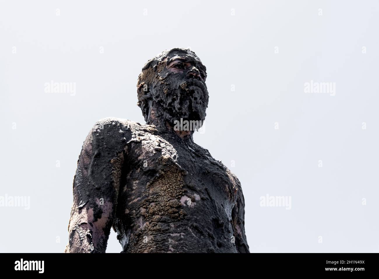 Man covered in oil on the beach at Porto da Barra in Salvador, Bahia ...