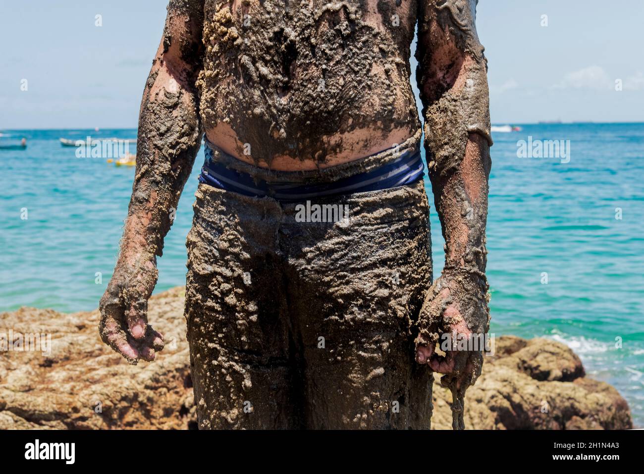 Man covered in oil on the beach at Porto da Barra in Salvador, Bahia ...