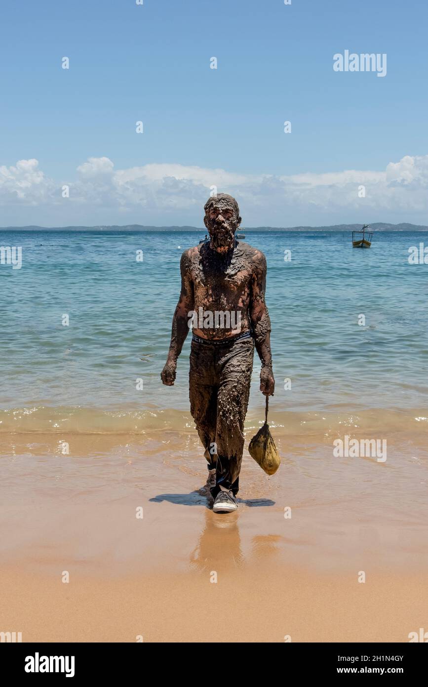 Man covered in oil on the beach at Porto da Barra in Salvador, Bahia ...