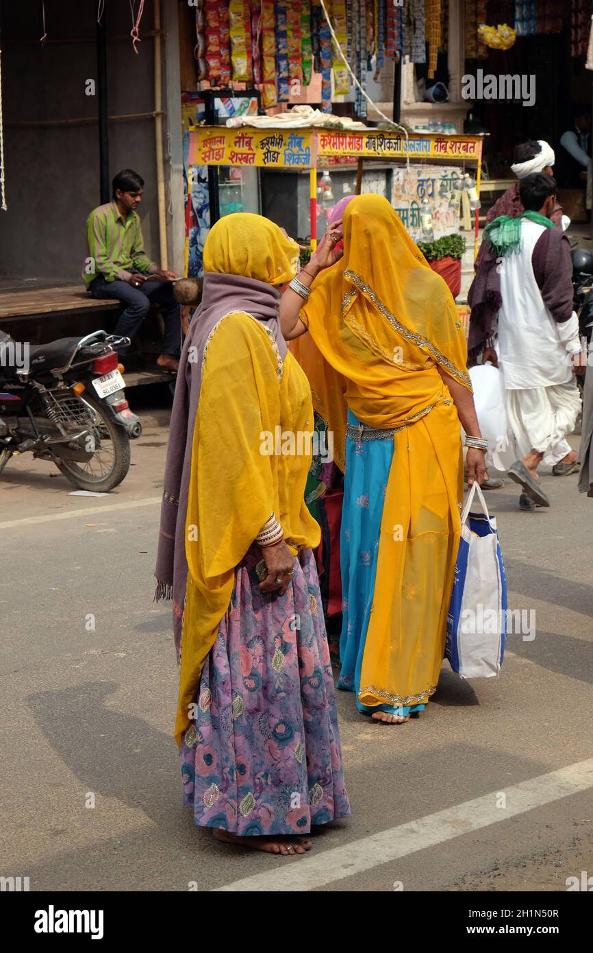 Indian women with traditional colored sari on the street of Pushkar ...