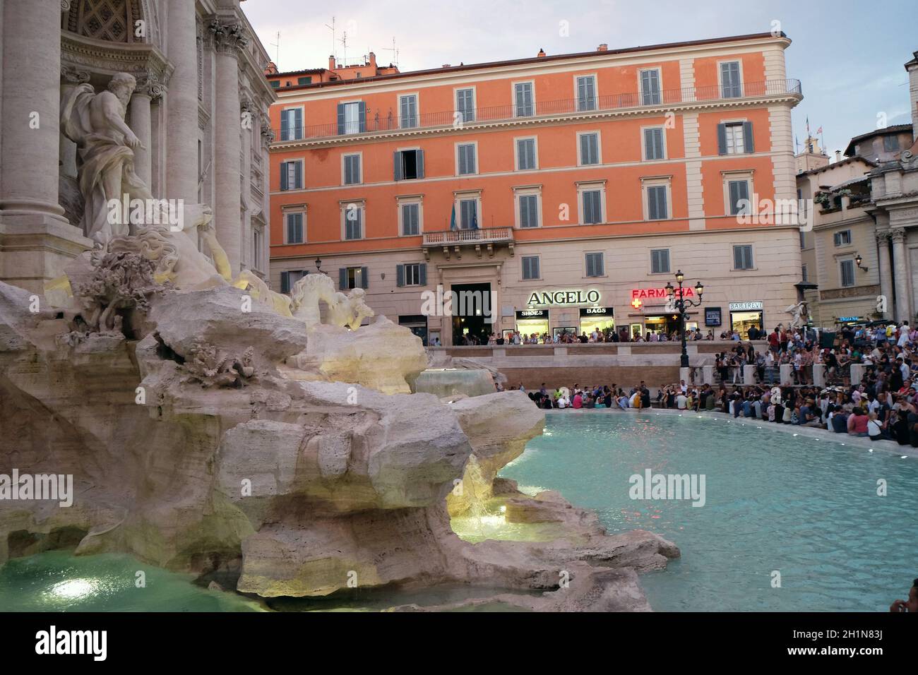 Crowd of tourists visiting and posing in the front of theTrevi Fountain ...
