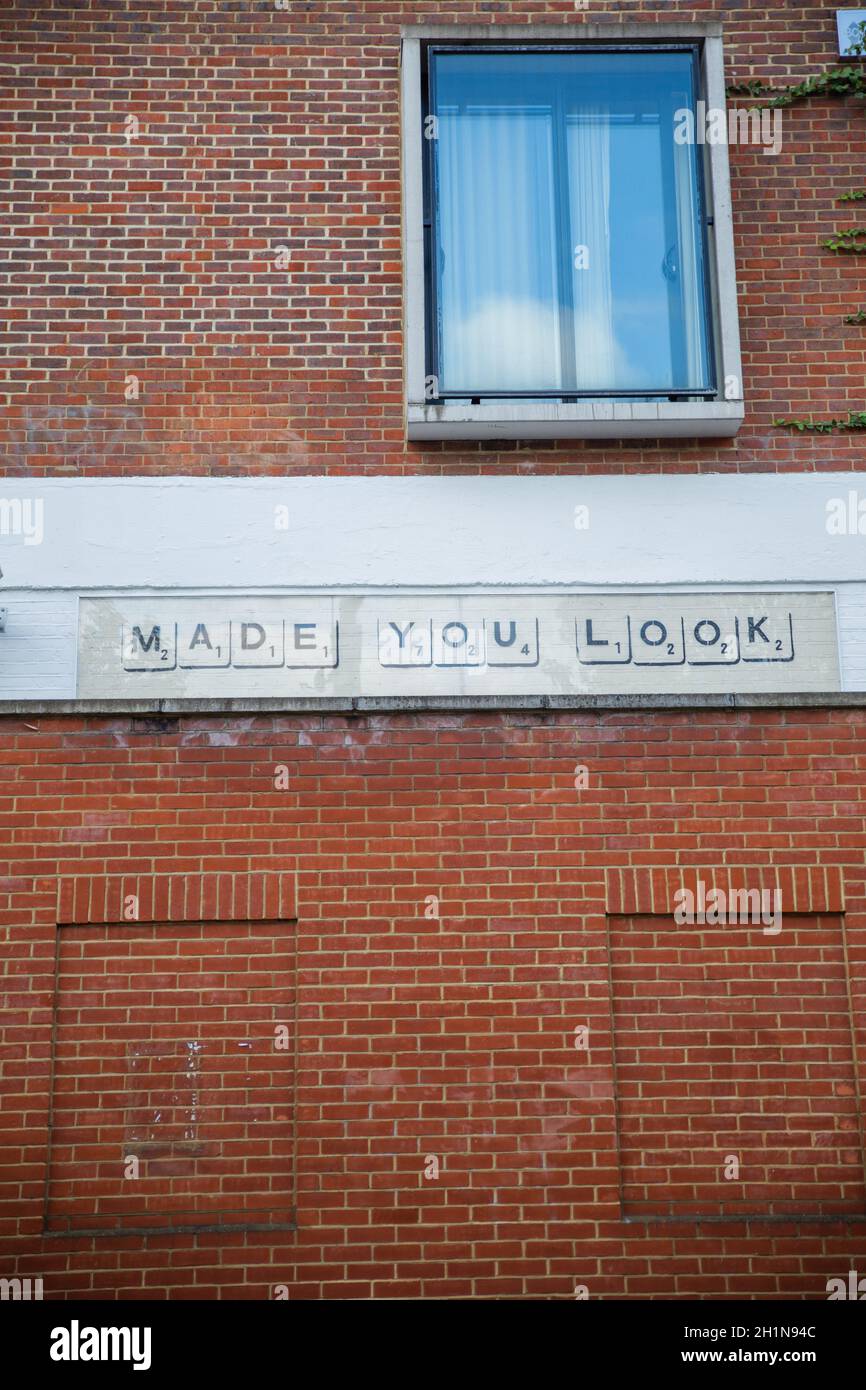Made you look message under a window on red brick wall. Fun written ...