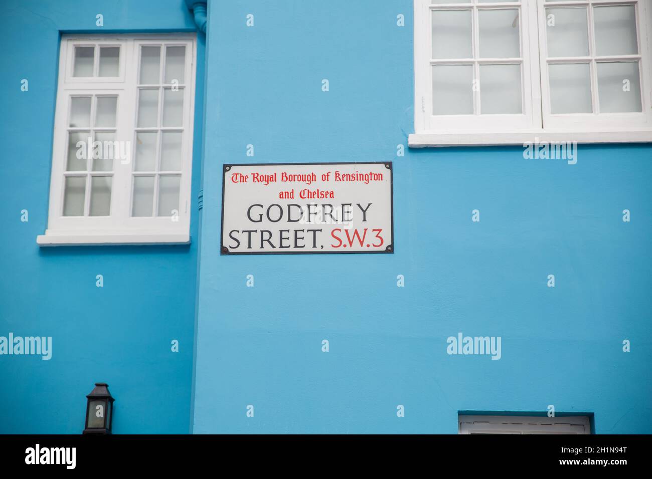 Address sign for Godfrey street on blue wall next to windows. Address ...