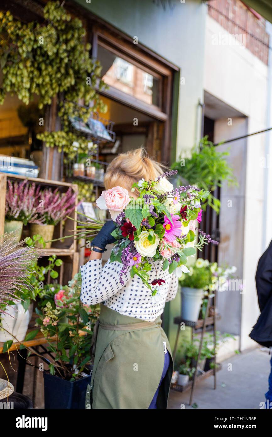 Brunette woman holding and covering her face behind bouquet of mixed ...