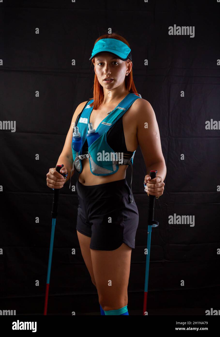 Beautiful girl marathon runner in blue jogging equipment and trekking ...