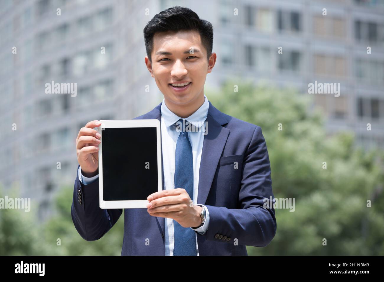 Confident businessman using a tablet computer Stock Photo - Alamy