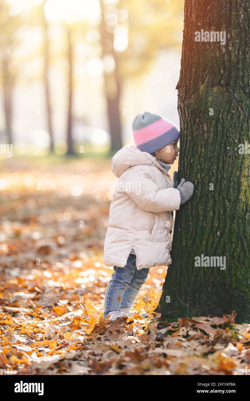 little girl hugs a tree, autumn Stock Photo - Alamy