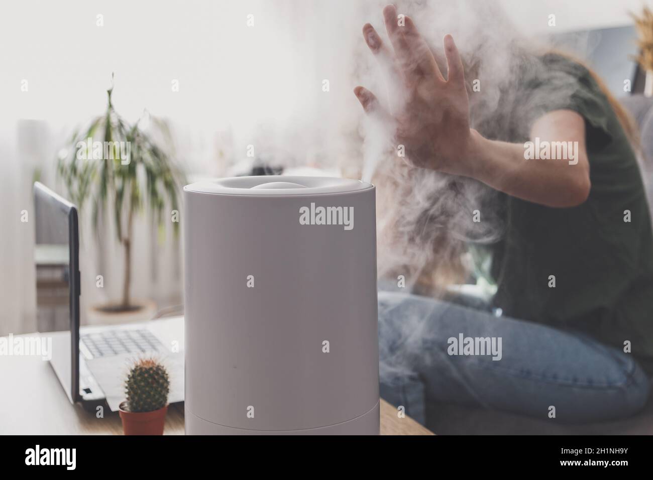 Woman freelancer uses a household humidifier in the workplace to ...