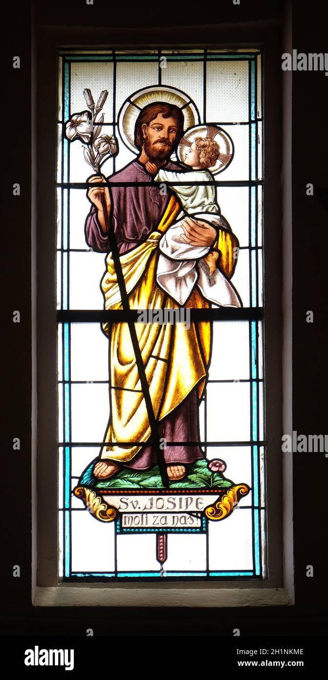 Saint Joseph holding baby Jesus, stained glass window in the parish ...