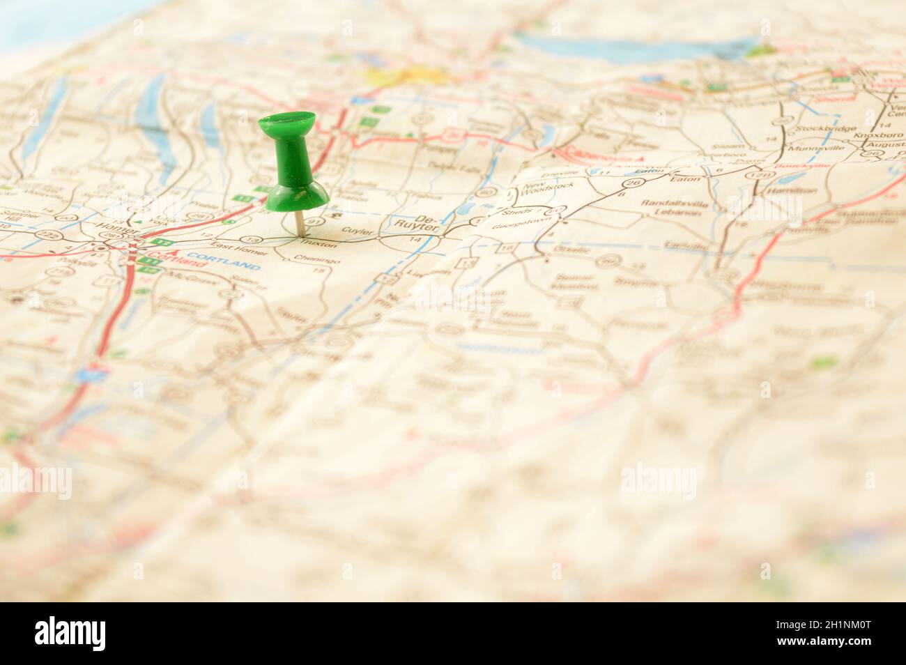 A green pin pressed into a map detailing a point of interest Stock ...