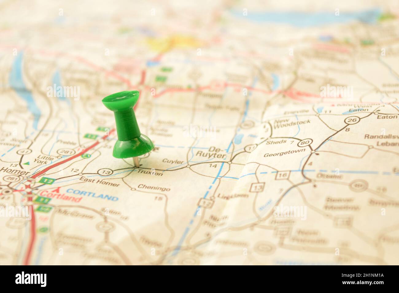 A green pin pressed into a map detailing a point of interest Stock ...