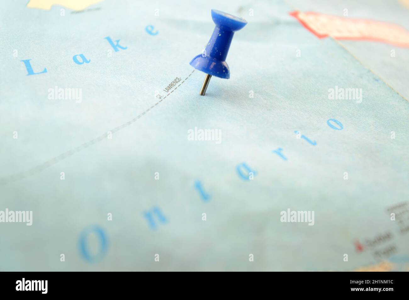 A blue pin point pressed into a map detailing Lake Ontario which is one ...