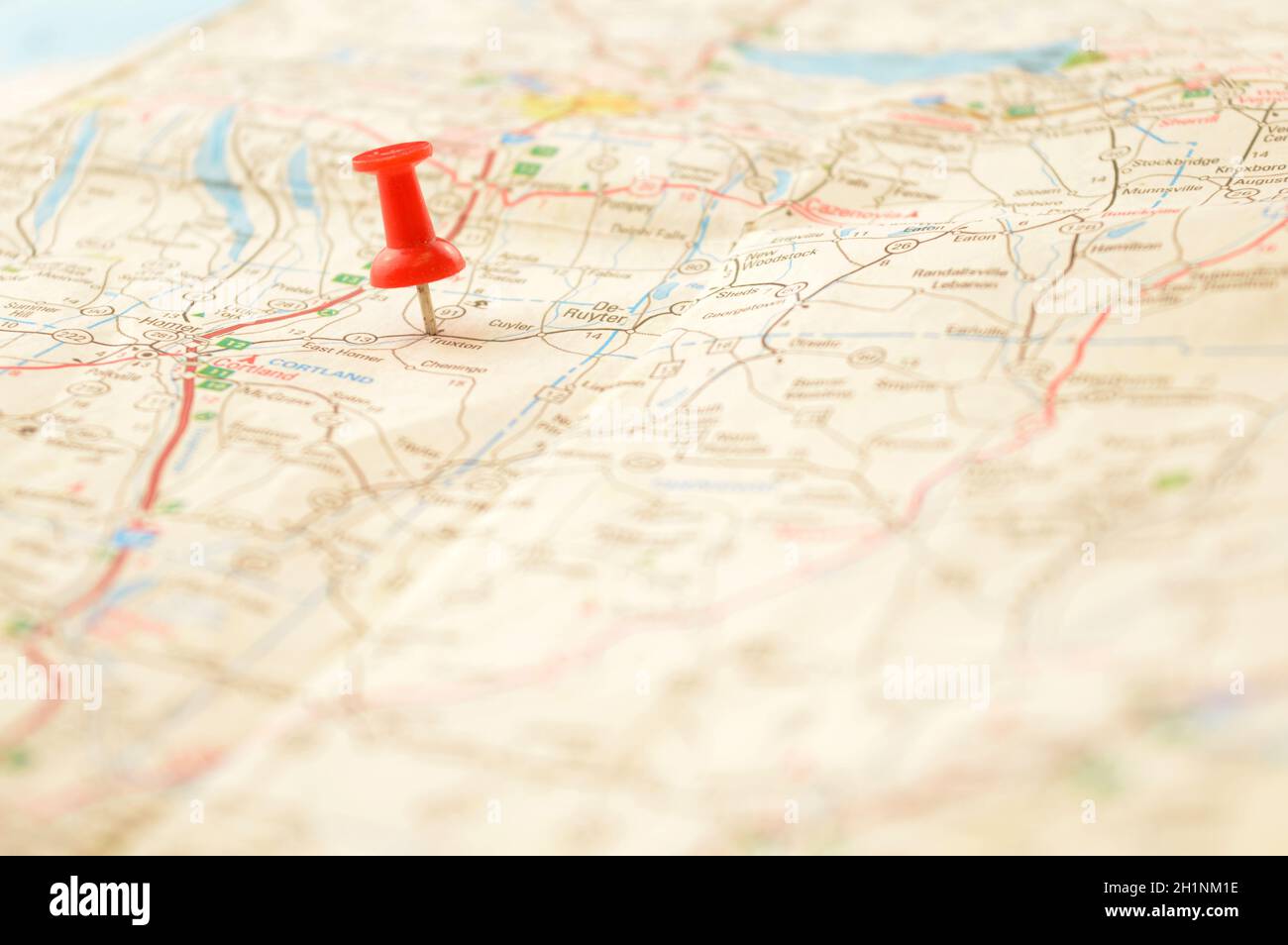 A red pin pressed into a map detailing a point of interest Stock Photo ...