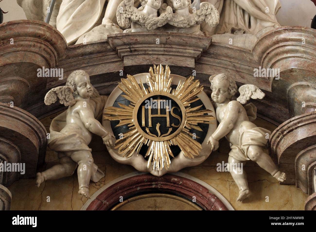 The angels hold the IHS signm statue on the altar in the Church of ...