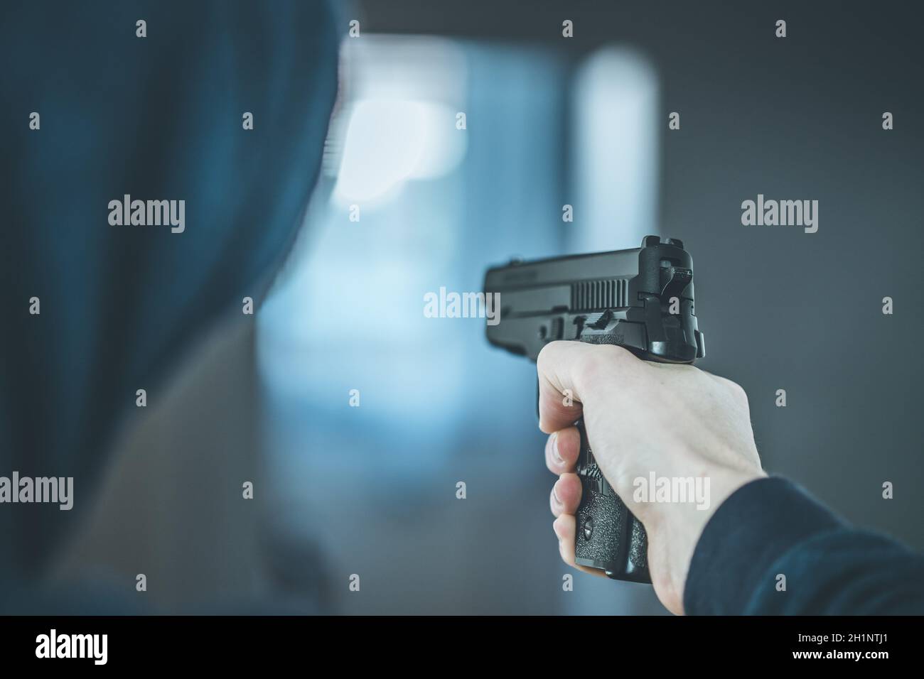 Robber or criminal is aiming with a black gun, blurry face Stock Photo ...