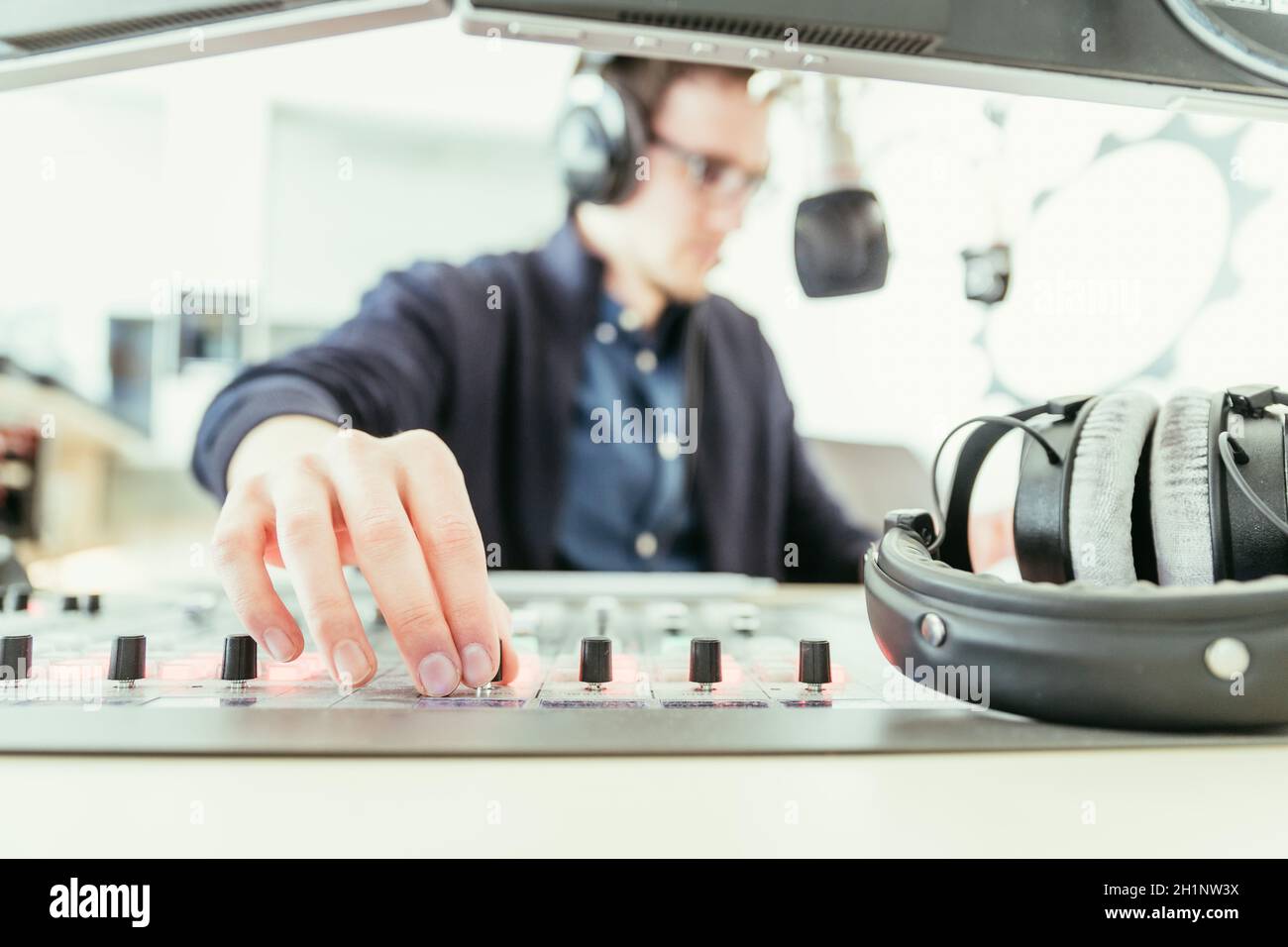 Young man in the broadcasting studio, radio, talking into the ...