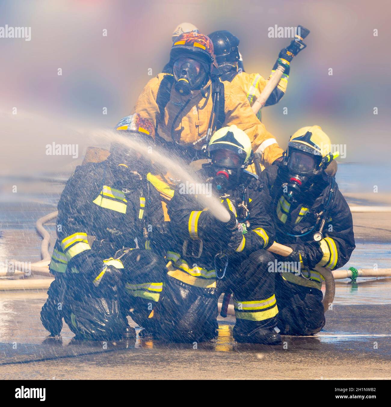 firefighters with hose extinguish a fire Stock Photo - Alamy