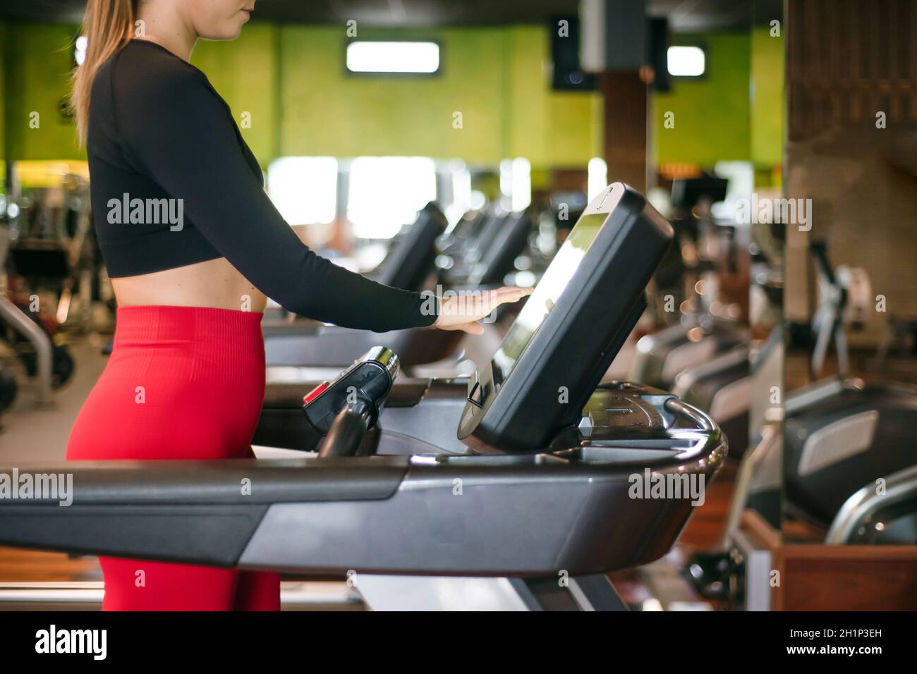 Woman point to button of speed control of treadmill in fitness center ...