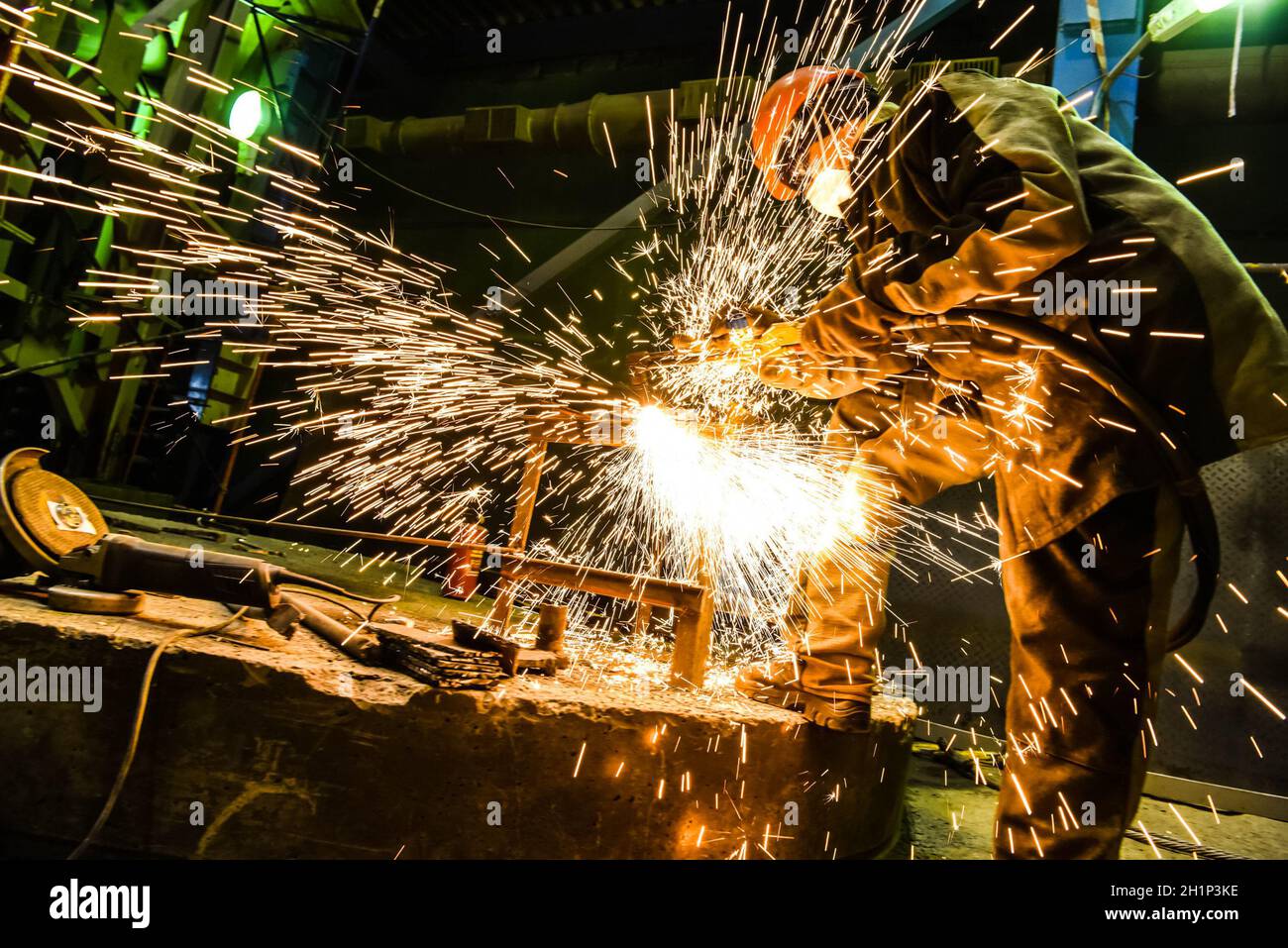 The welder cooks a steel structure. Sparks are flying. The work of a ...