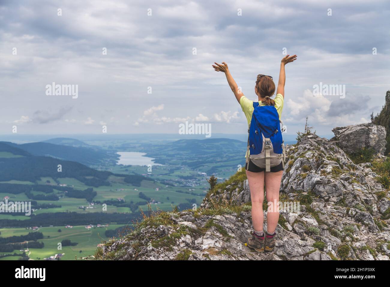 Young slim backpacker tourist girl is enjoying the view on rocky ...