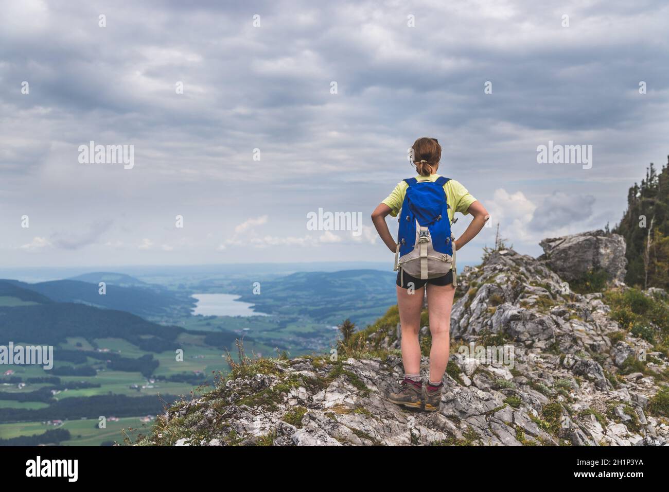 Young slim backpacker tourist girl is enjoying the view on rocky ...