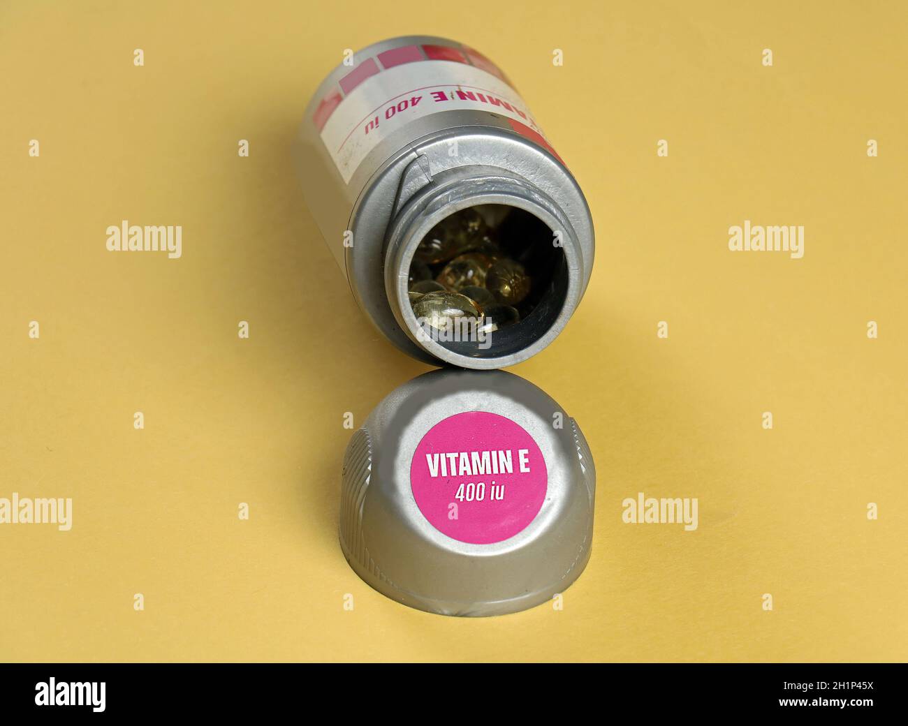 Vitamin E food supplement gel pills inside open container on yellow ...
