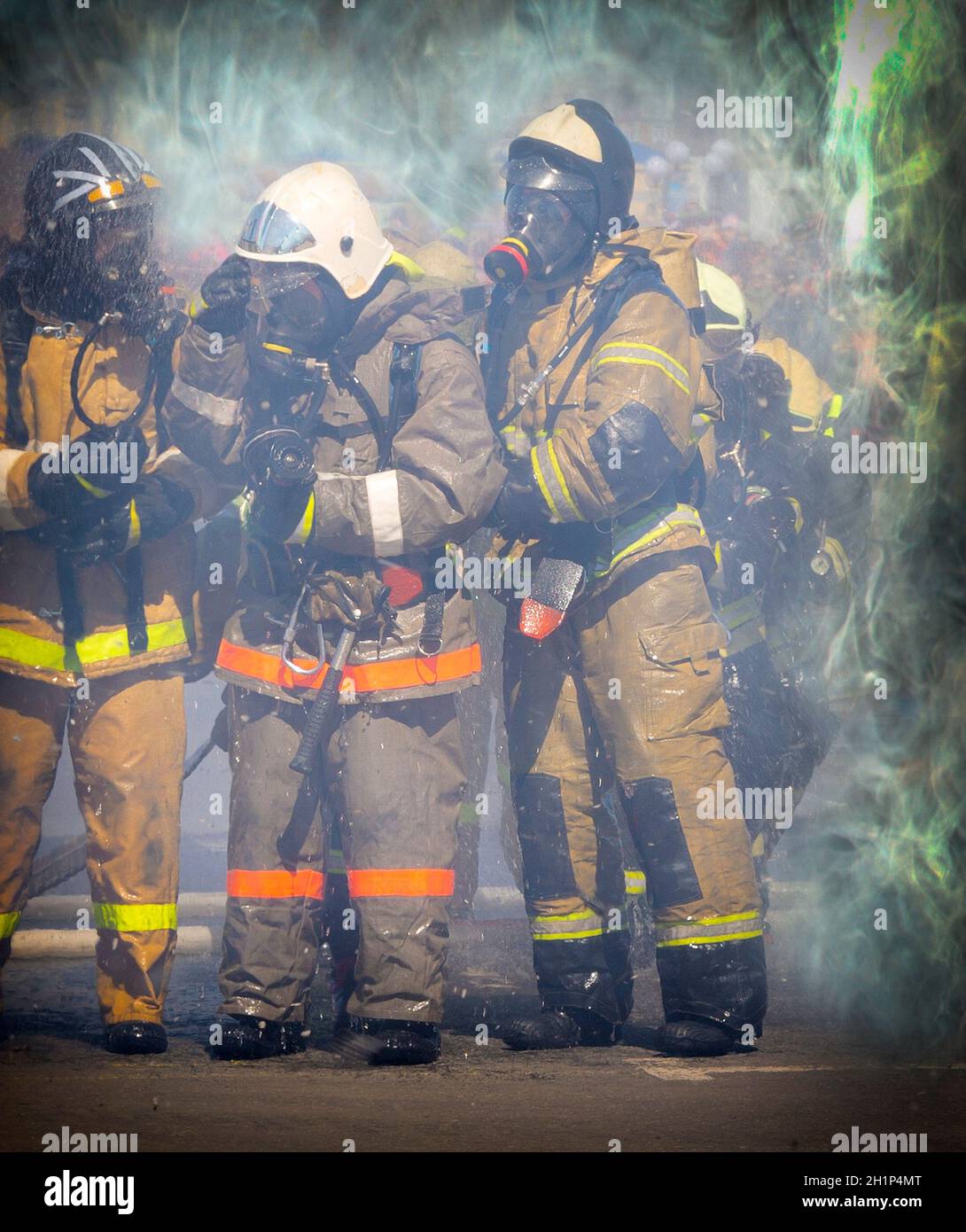 Group of firefighters fighting a fire Close up Stock Photo - Alamy