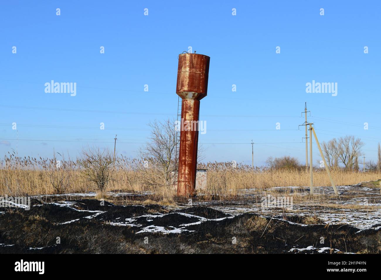 The old rusty water tower tilted. An old rustic communal communication ...