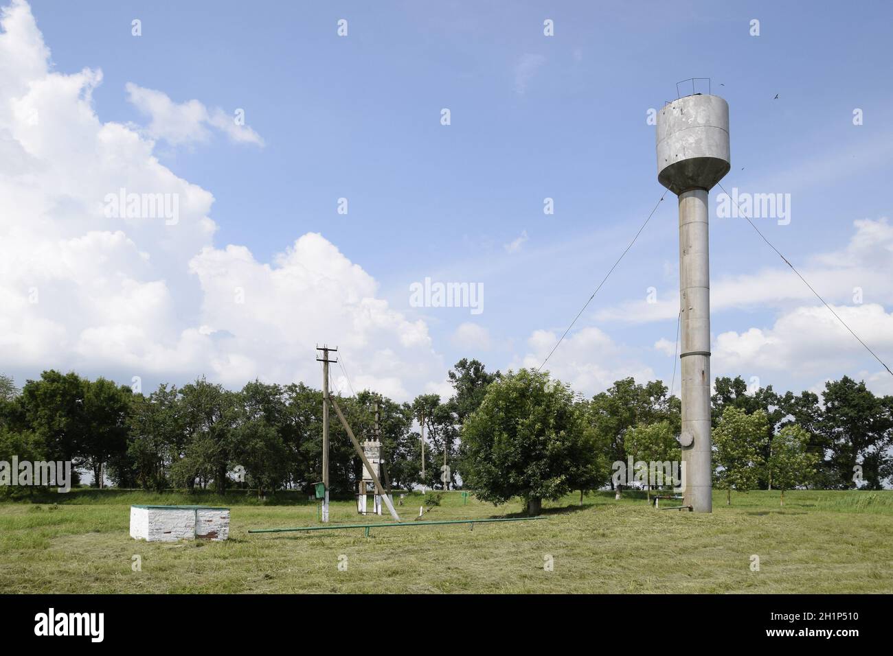 Silver Water Tower among green grass and trees Stock Photo - Alamy
