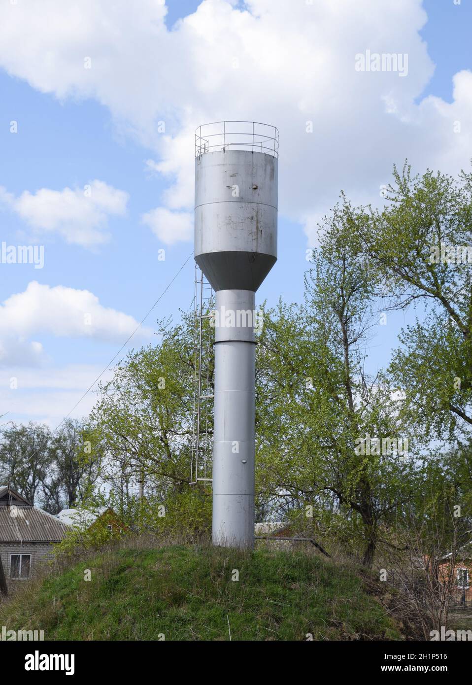 Silver Water Tower among green grass and trees Stock Photo - Alamy