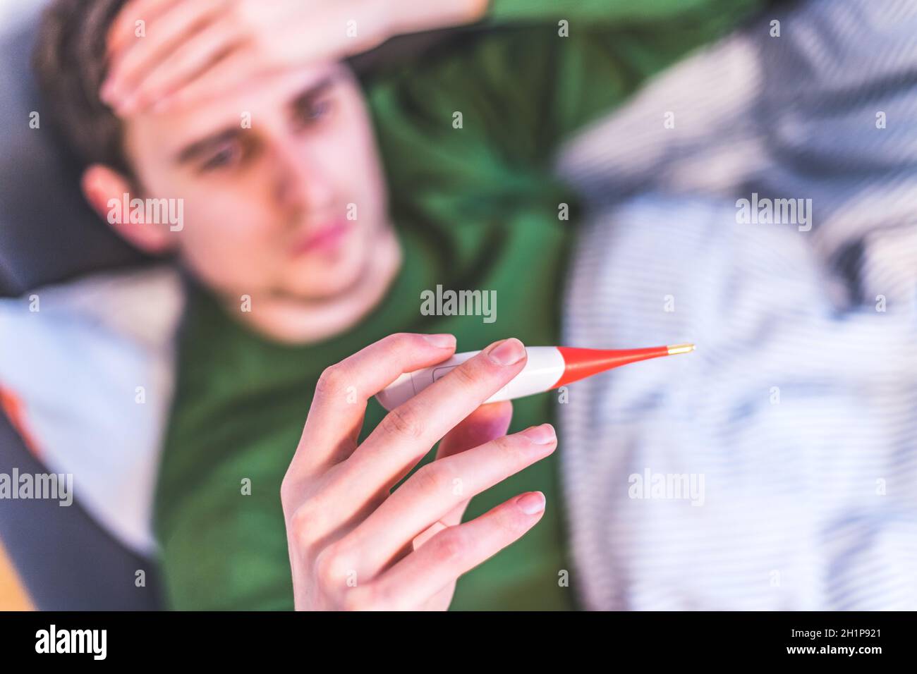Man is holding a red fever thermometer in his hand Stock Photo - Alamy