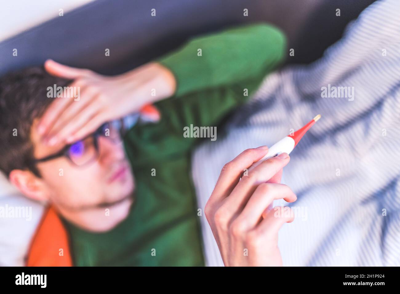 Man is holding a red fever thermometer in his hand Stock Photo - Alamy