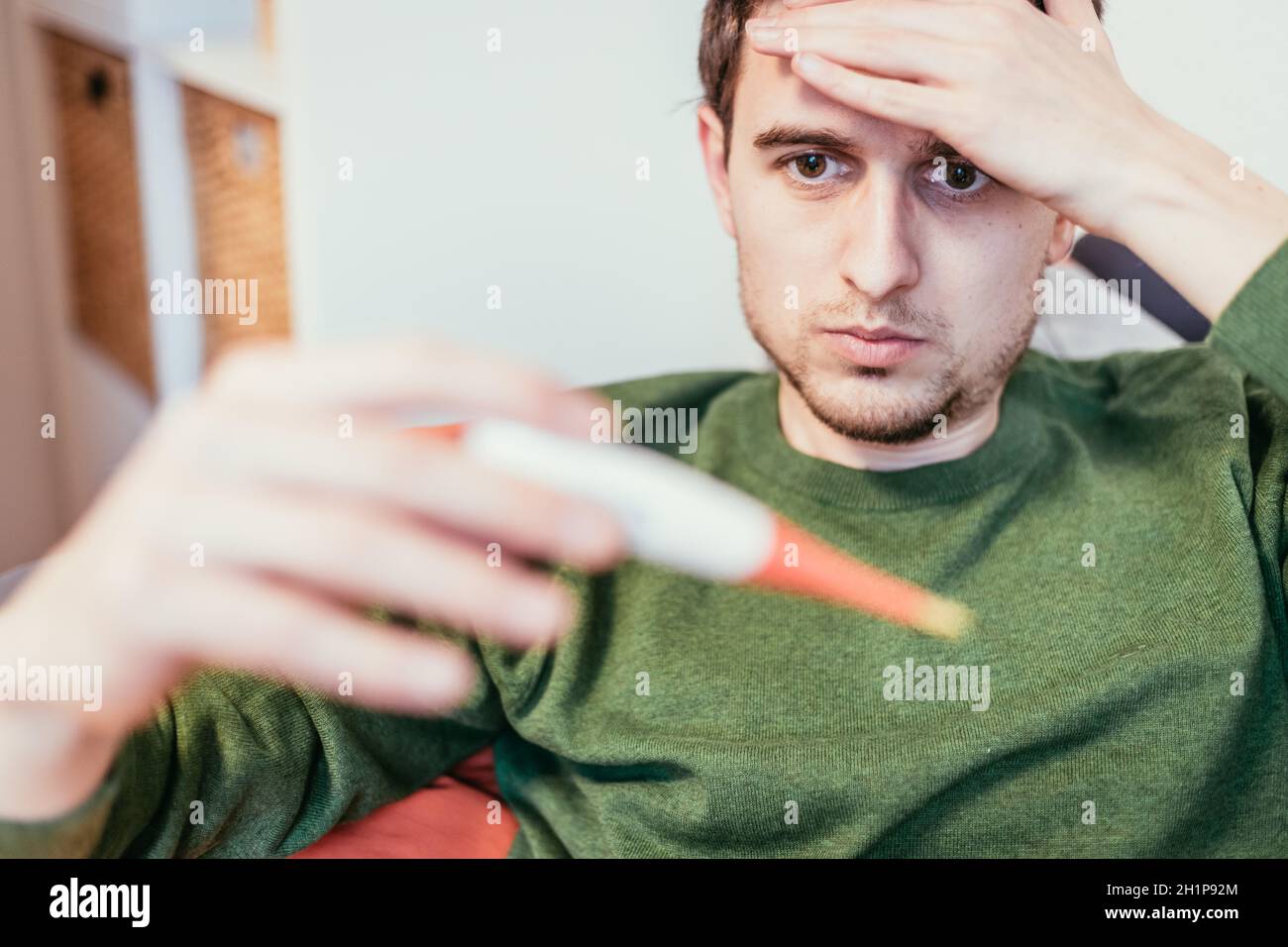 Man is holding a red fever thermometer in his hand Stock Photo - Alamy