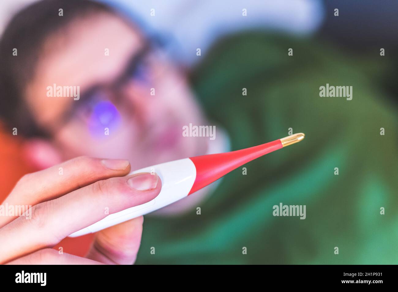 Man is holding a red fever thermometer in his hand Stock Photo - Alamy