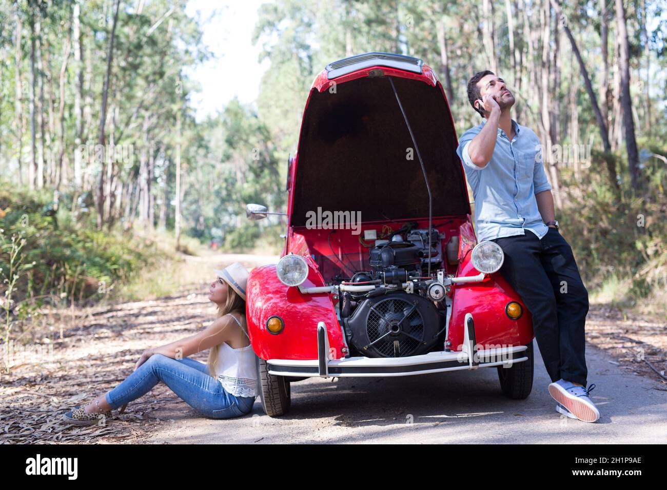 Friends on a roadtrip having a problem with their old car Stock Photo ...